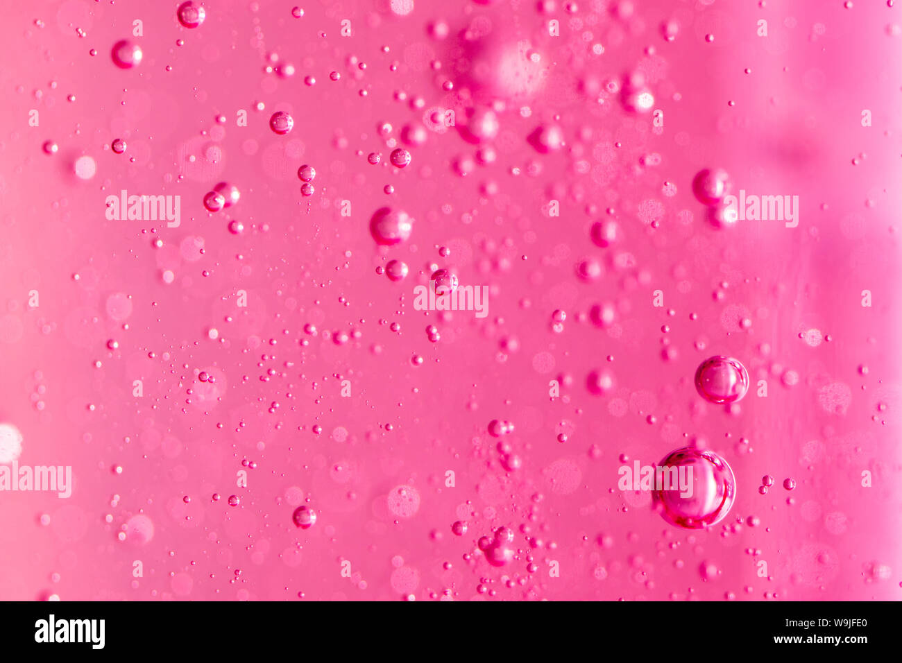 Macro Oxygen bubbles in water on a pink background, concept such as ...