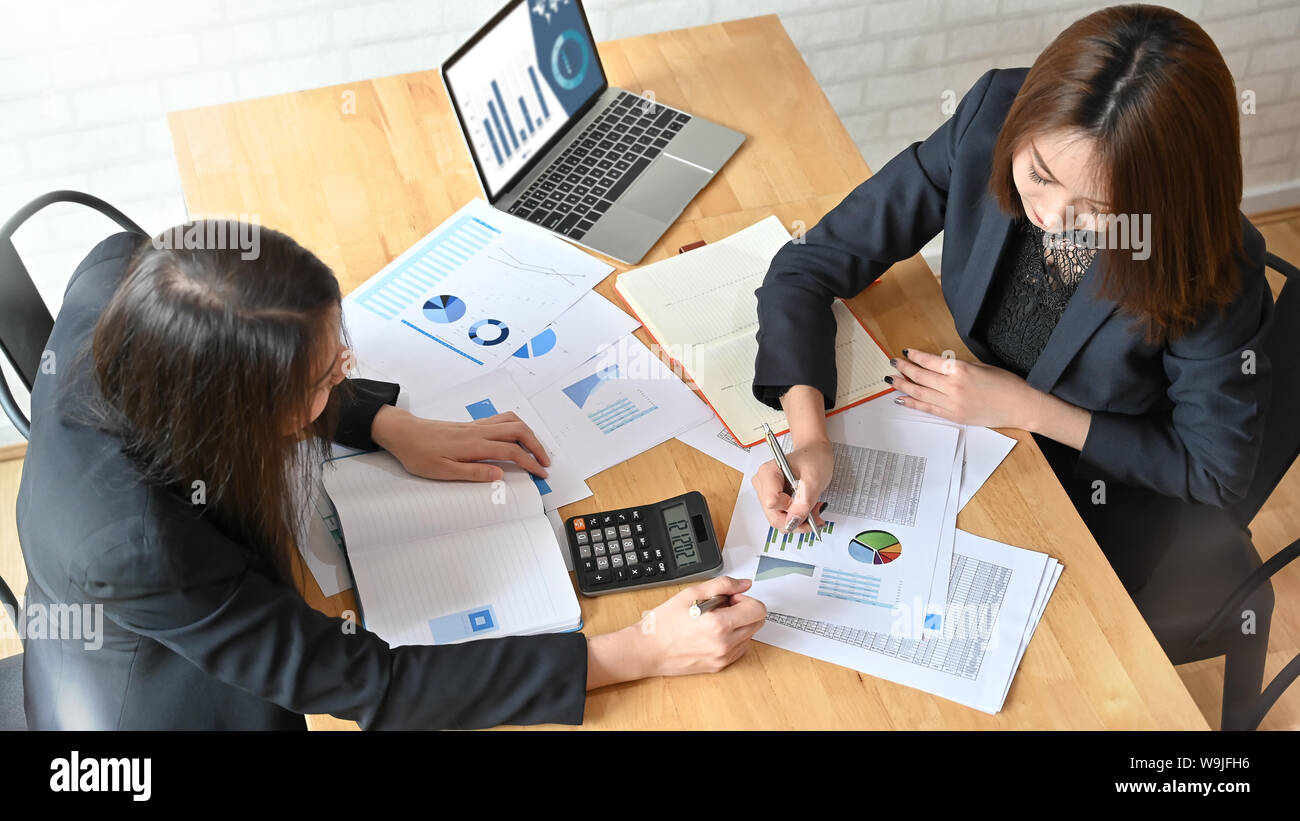 Overhead shot of business team consulting the solution with graphs and ...