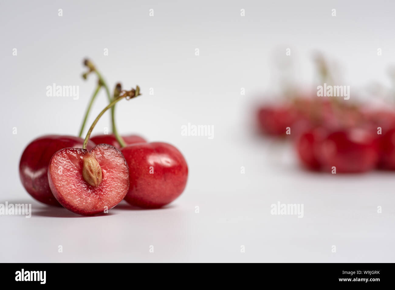 Bunch of fresh cherries and an open cherry with a seed Stock Photo - Alamy