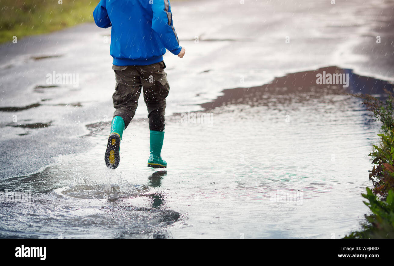 Child walking in wellies in puddle on rainy weather Stock Photo - Alamy