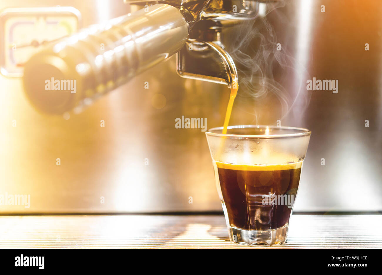Barista making a espresso with a classic coffee machine with steam in ...