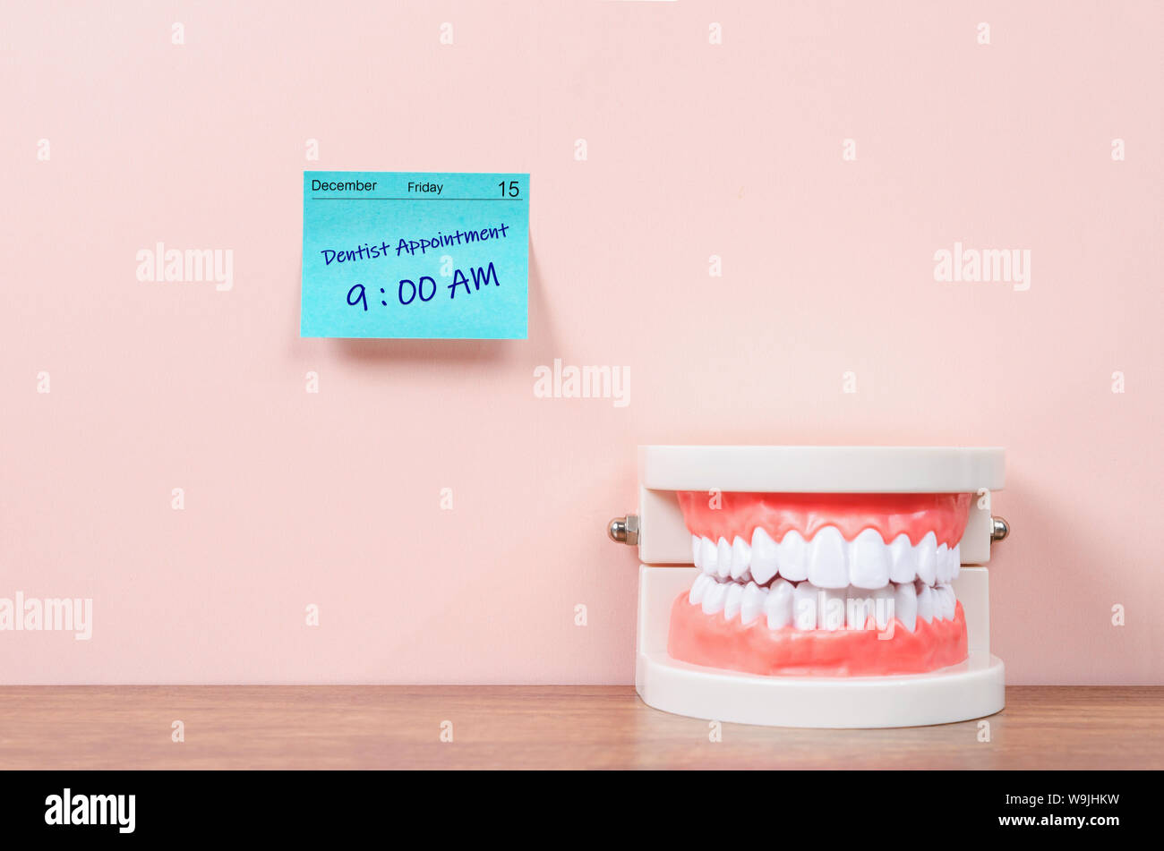 Dentist appointment on sticky note calendar with teeth model on table ...
