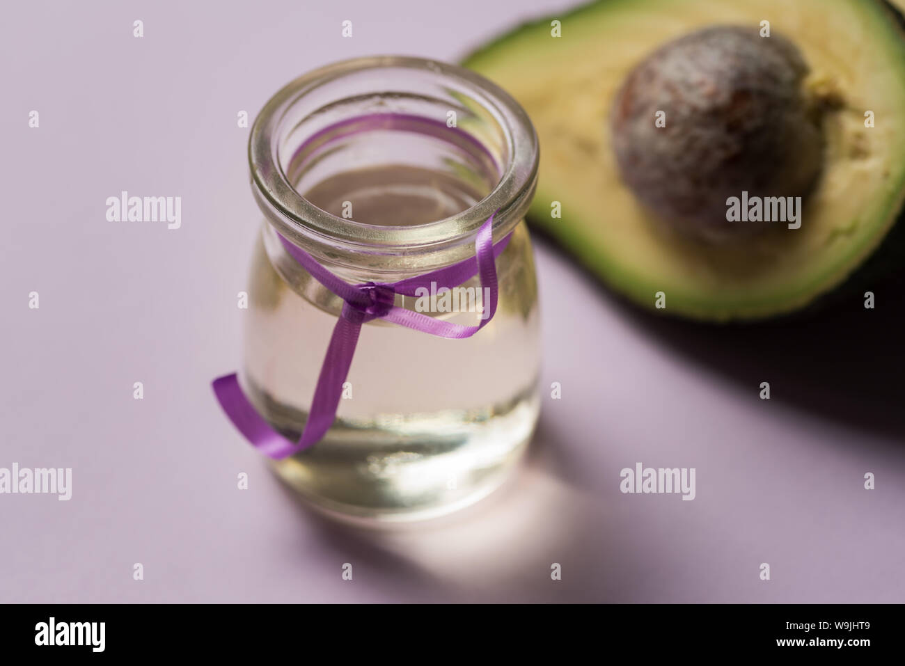 Freshly cut avocado on clean surface with avocado oil Stock Photo - Alamy