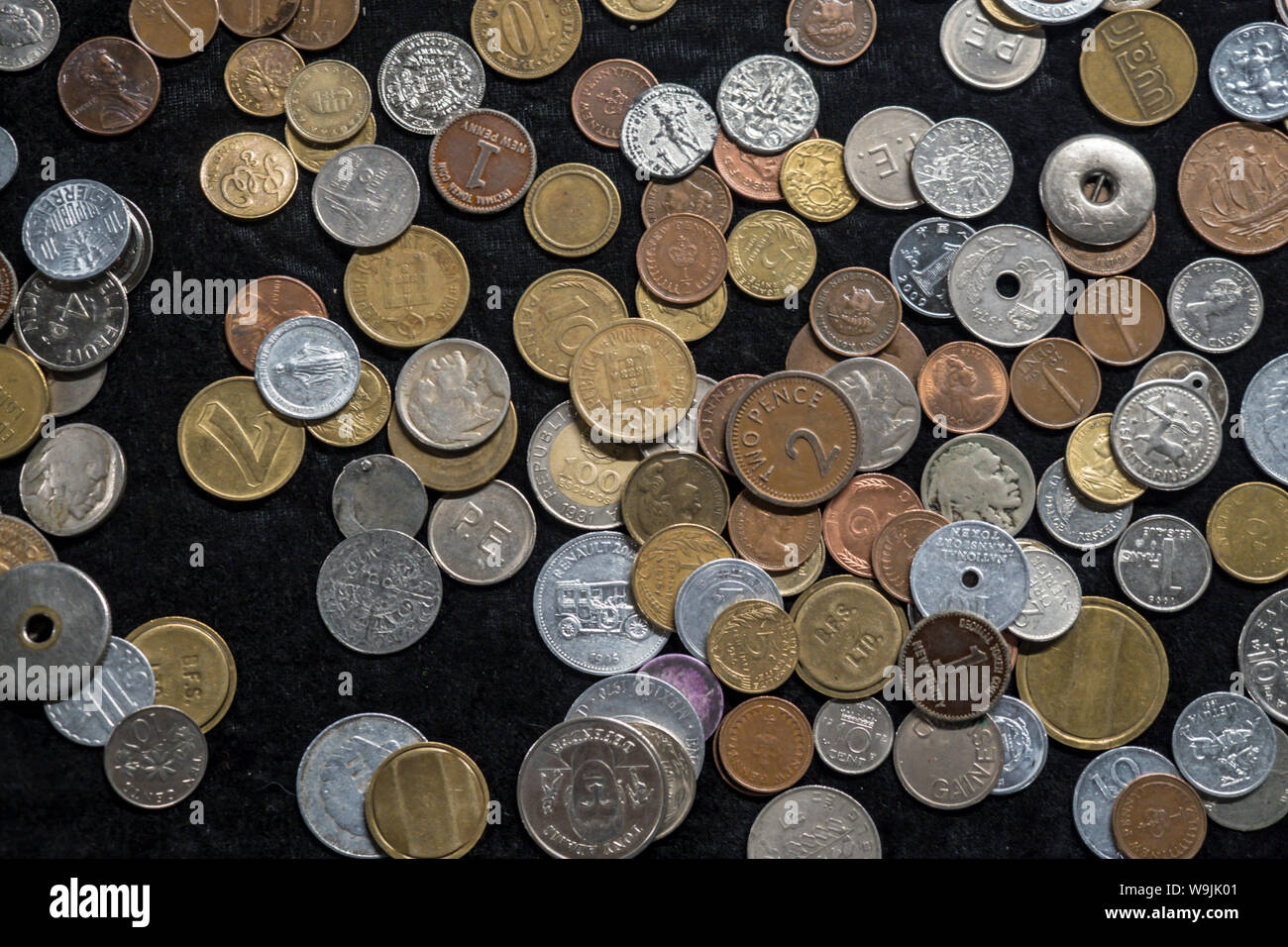 Miscellaneous coins on a black background Stock Photo - Alamy