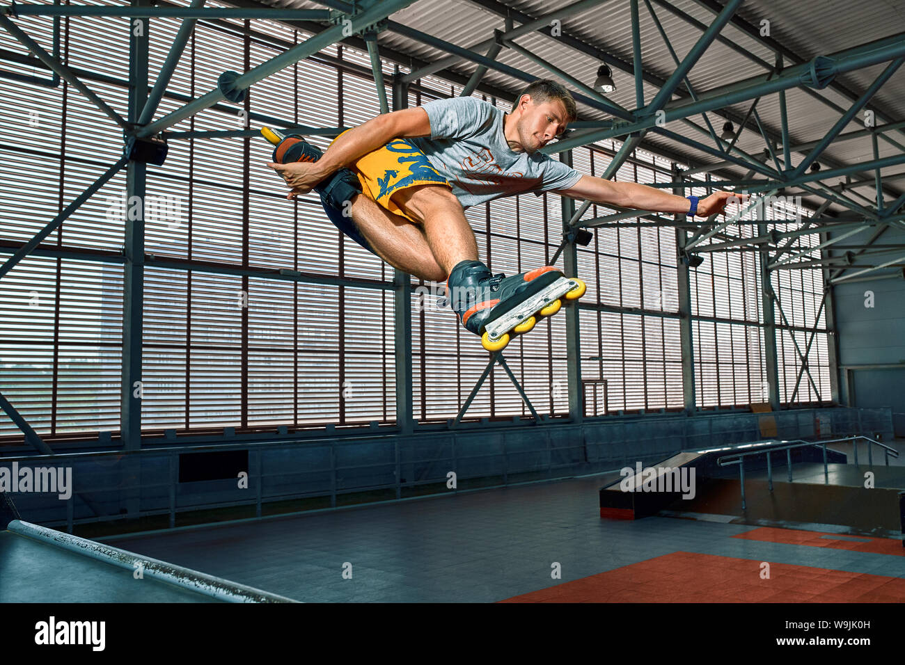 Rollerblader jump high from big air ramp performing trick. Indoors ...