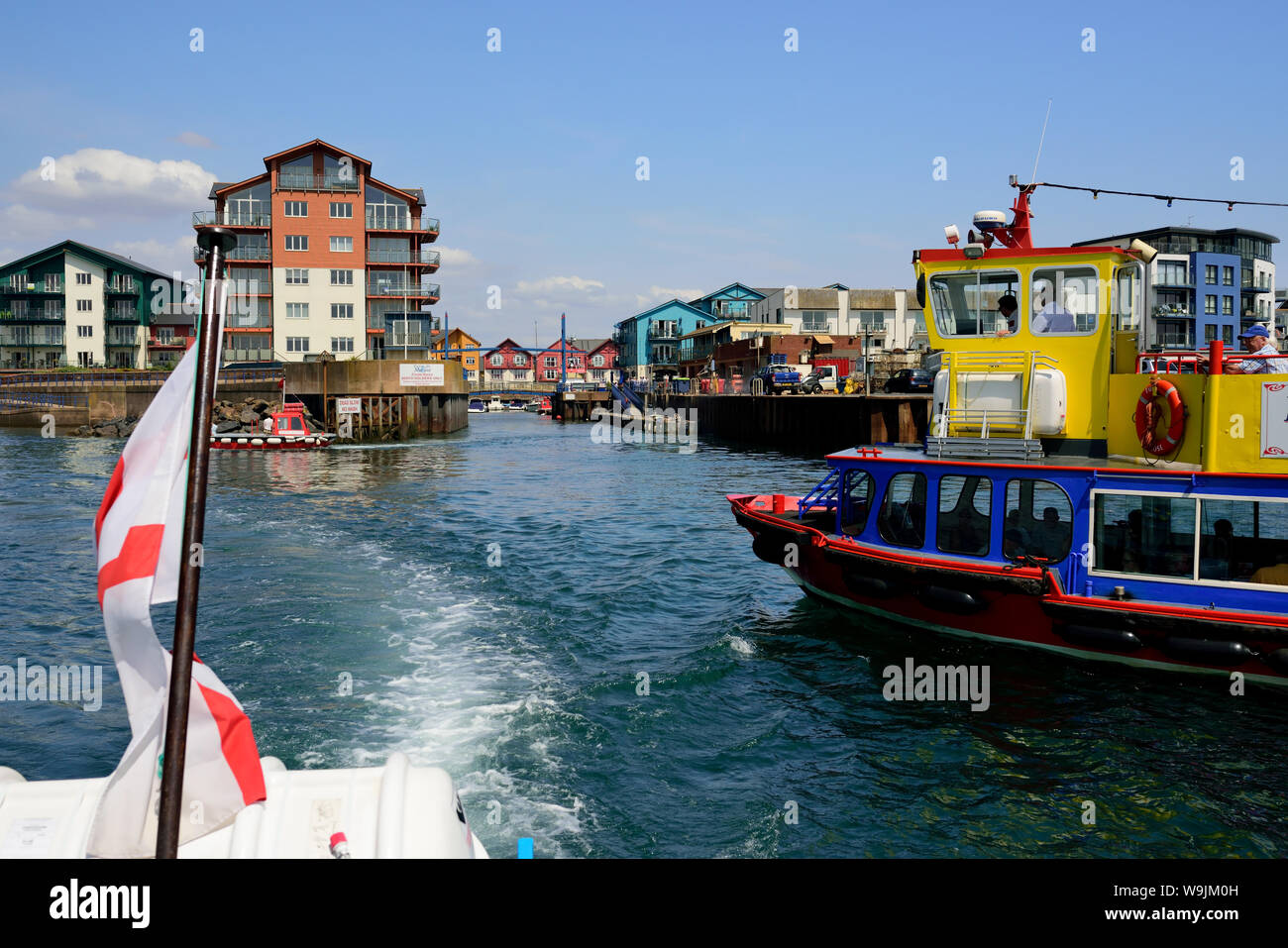 The Exe estuary at the entrance to Exmouth harbour, as boats leave and ...