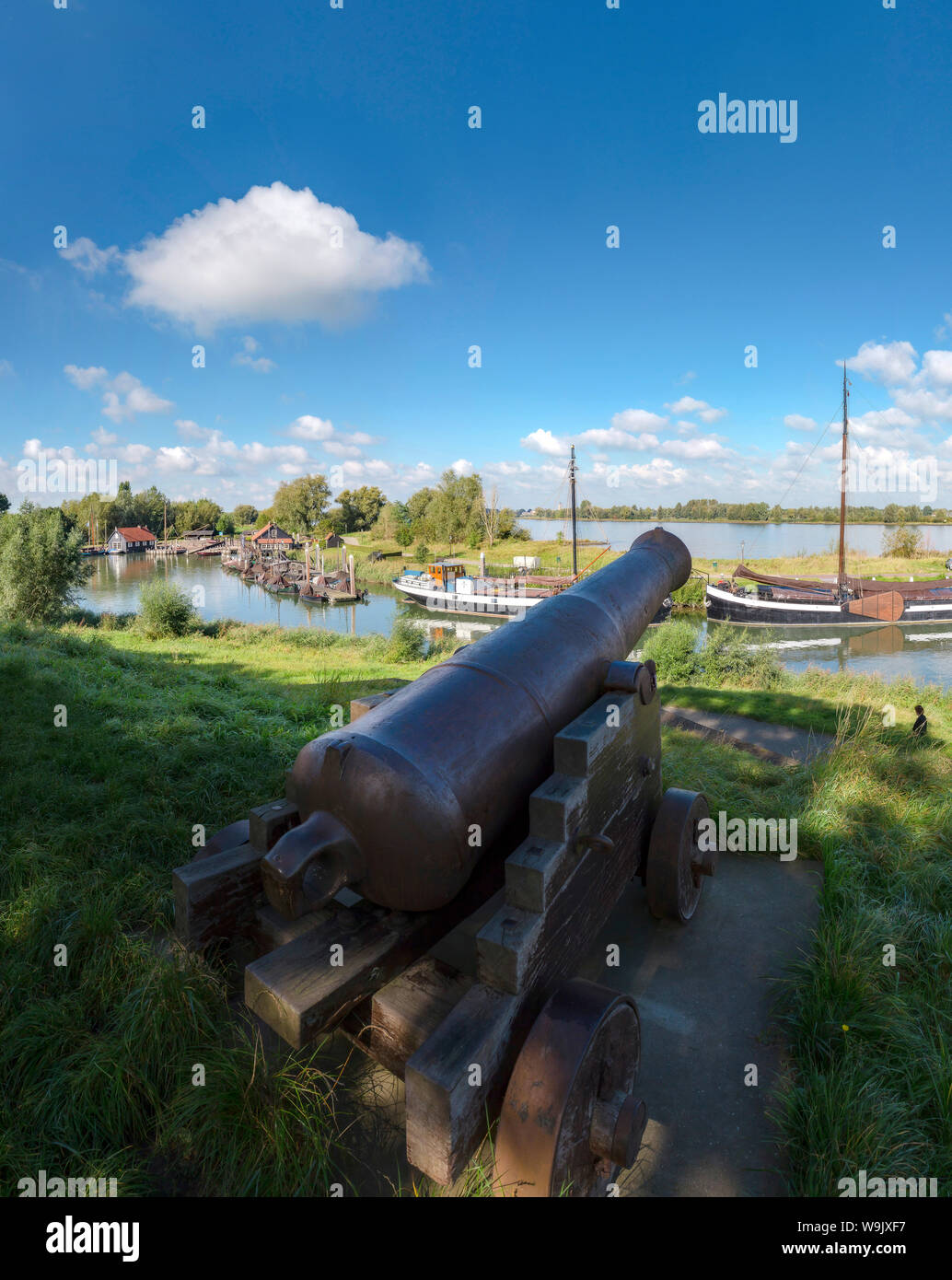 An ancient canon at the Historic Port and the river Boven-Merwede ...