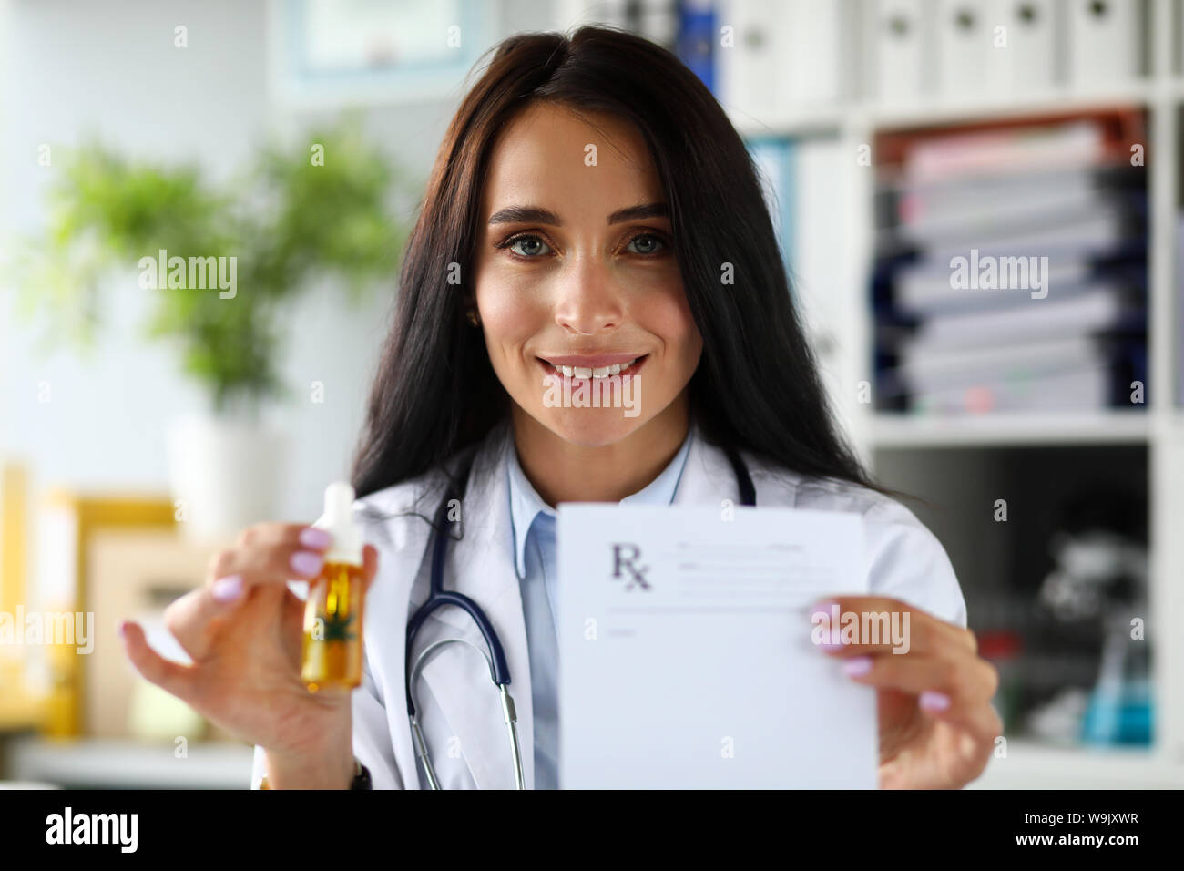 Female GP giving patient dropper jar of cannabis concentrate oil Stock ...