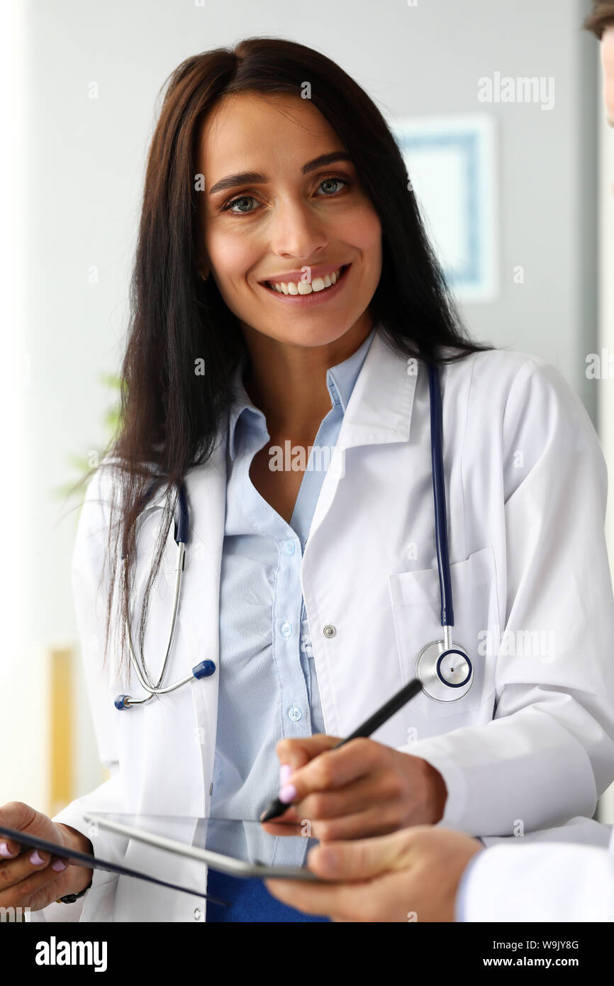 Smiling cheerful female GP making electronic notes Stock Photo - Alamy