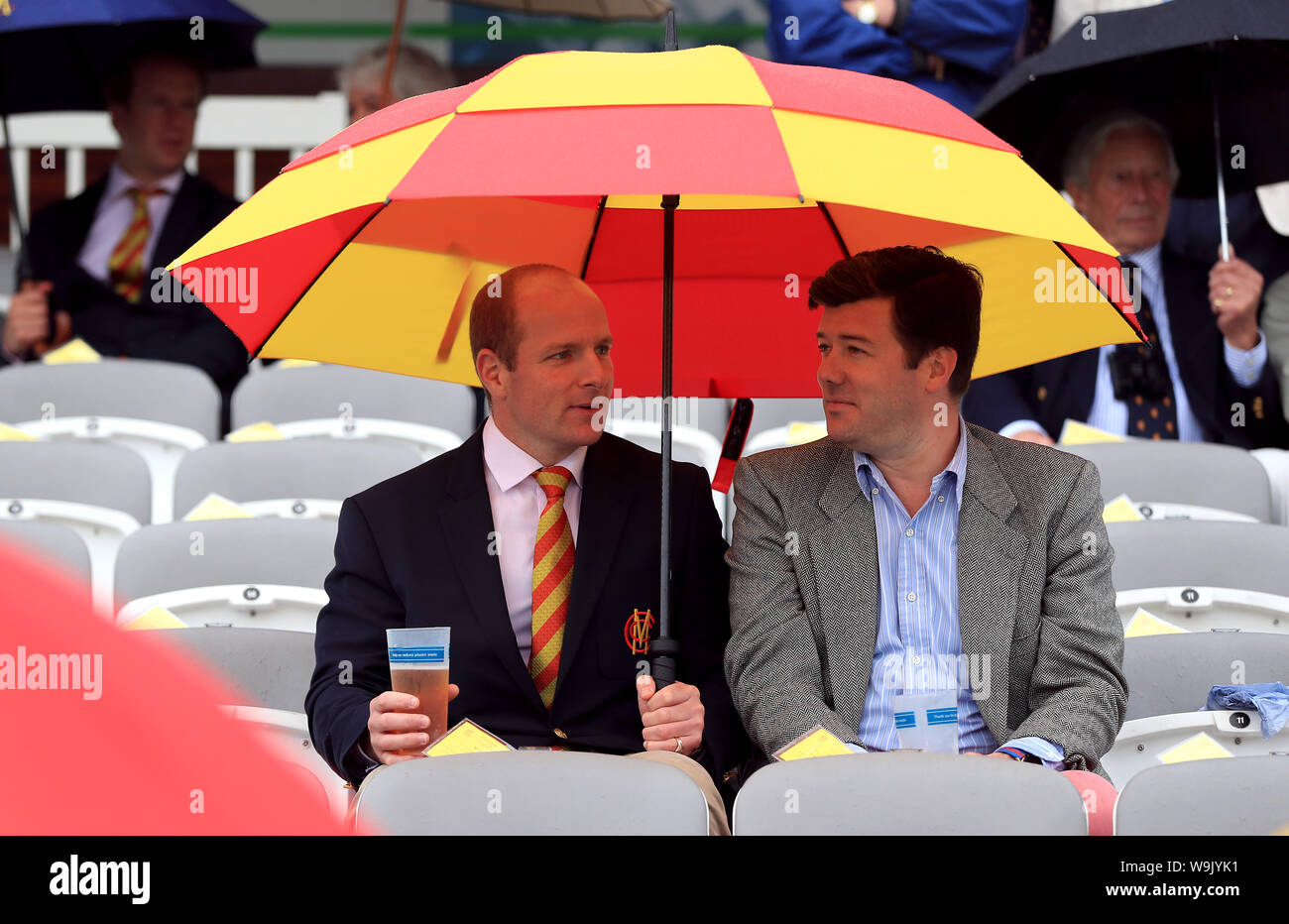 MCC members shelter under an umbrella during day one of the Ashes Test ...
