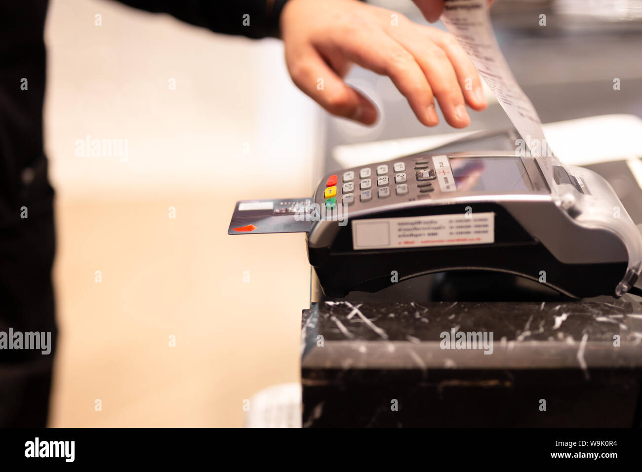 Male cashier hand put credit card in cash register for customer payment ...