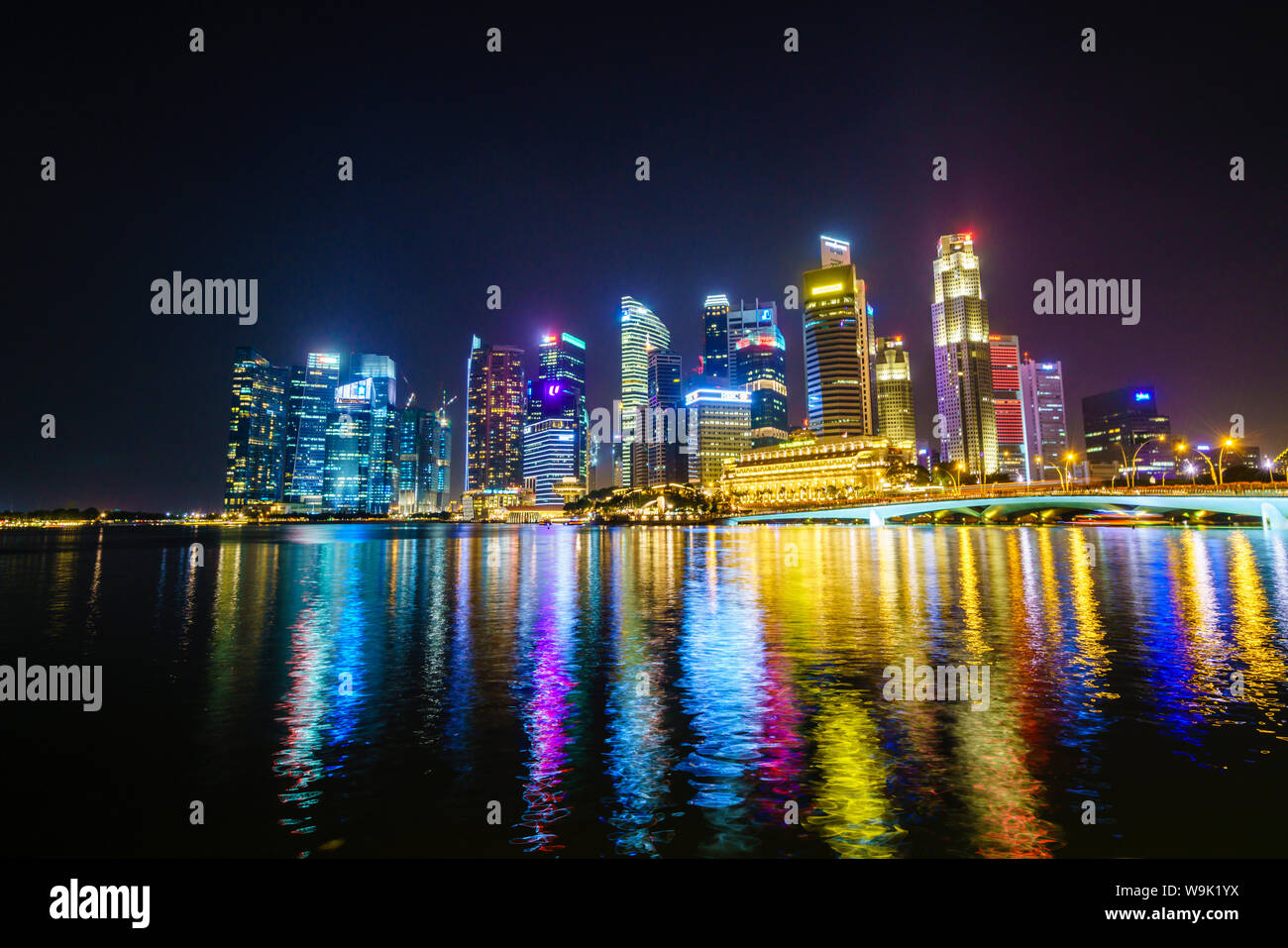 Singapore skyline from Marina Bay at night with the Fullerton Hotel and Jubilee Bridge ...