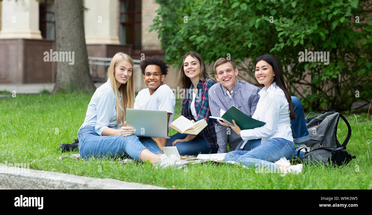 Happy college students resting in campus, smiling to camera Stock Photo ...