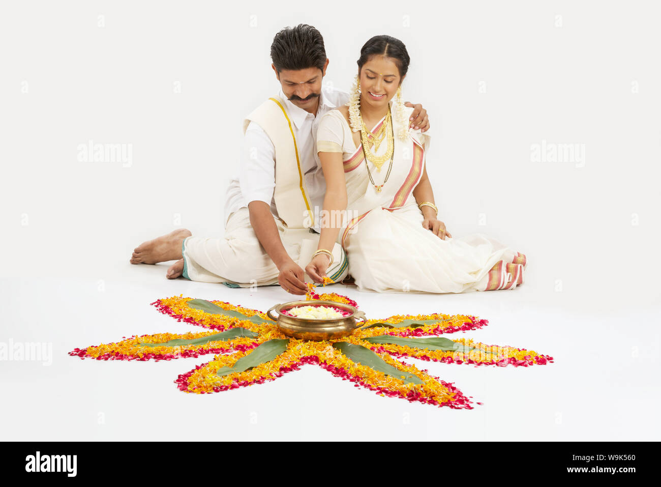 South Indian couple making rangoli Stock Photo - Alamy