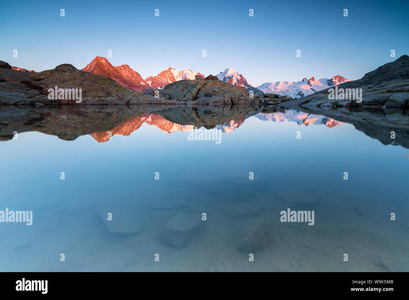 Snowy peaks reflected in the alpine lake at sunset, Fuorcla, Surlej, St ...