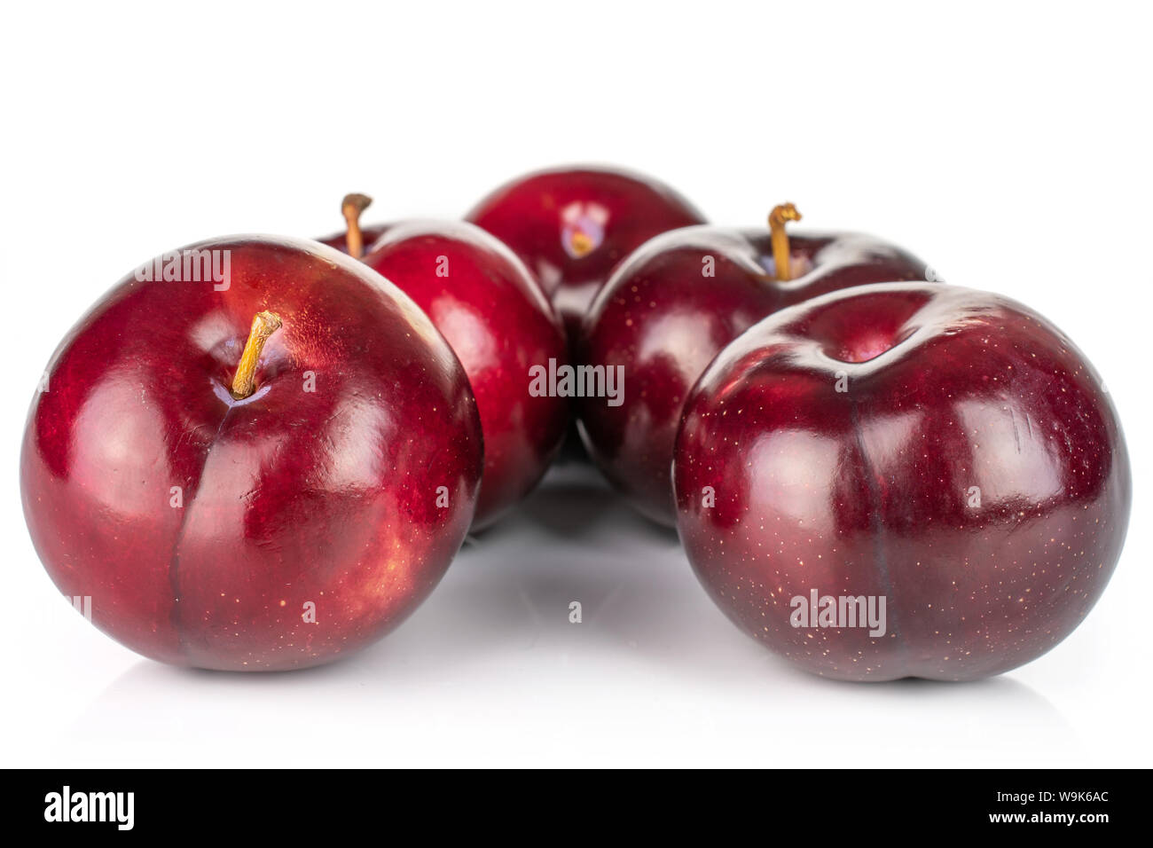 Group of five whole ripe red round plum arranged symmetrically isolated ...