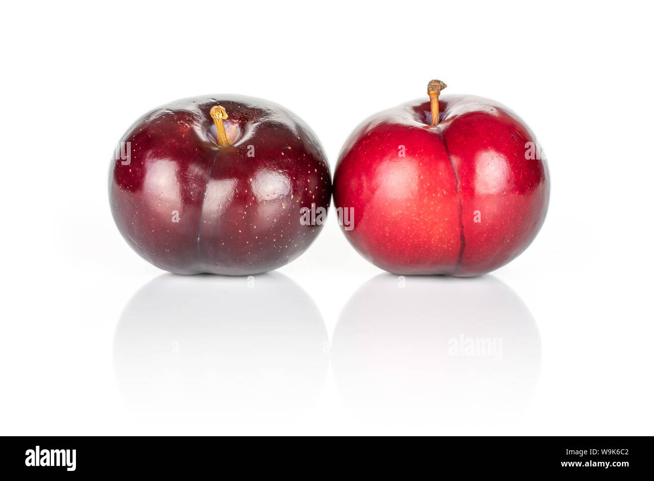 Group of two whole ripe red round plum isolated on white background ...