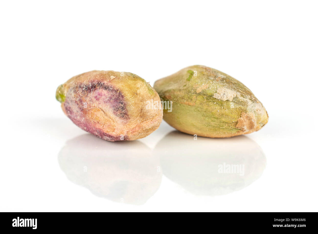 Group of two whole ripe green pistachio in closeup isolated on white ...
