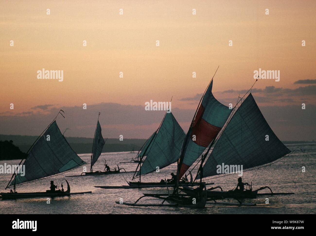 Outrigger fishing boats under sail, returning to the village of Bunutan ...