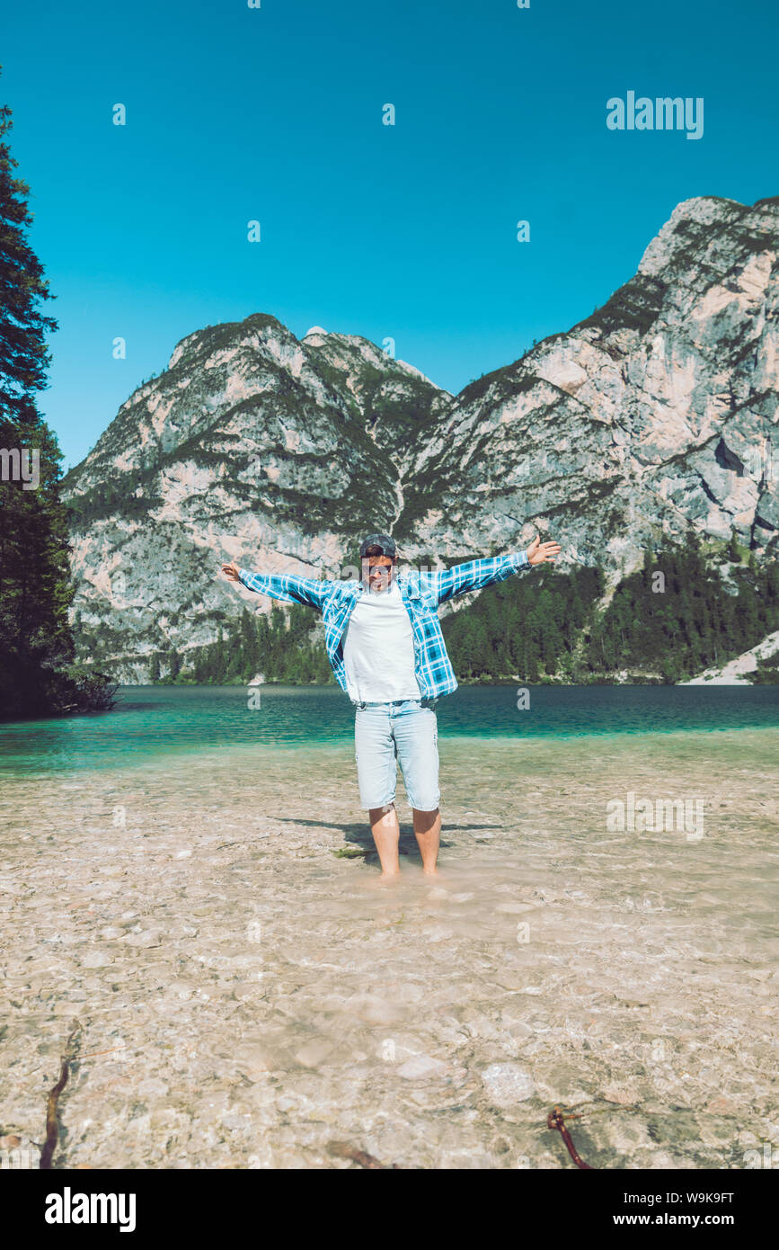 man rise up hands standing in lake mountains on background hiking ...