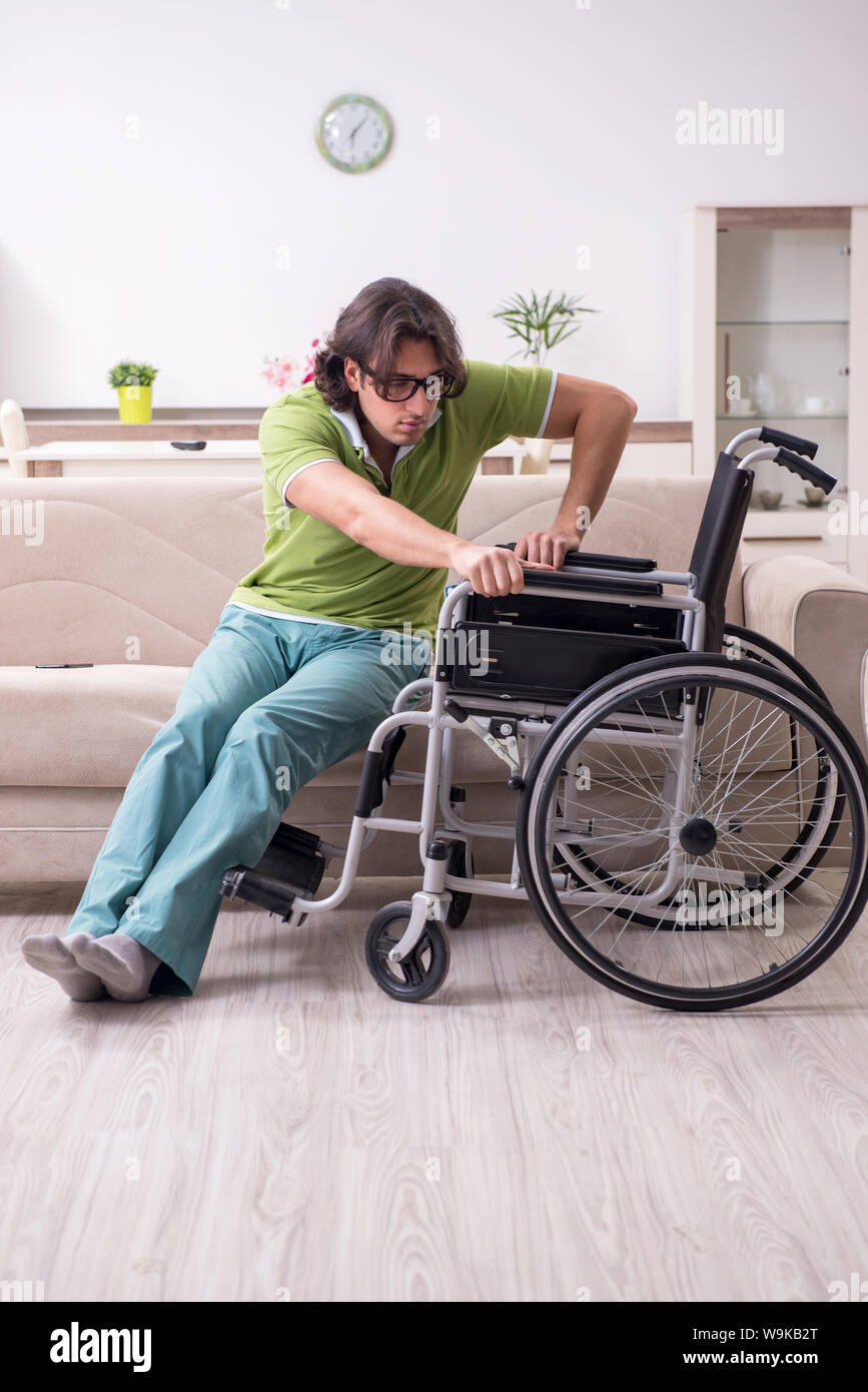 The young male invalid in wheelchair suffering at home Stock Photo - Alamy