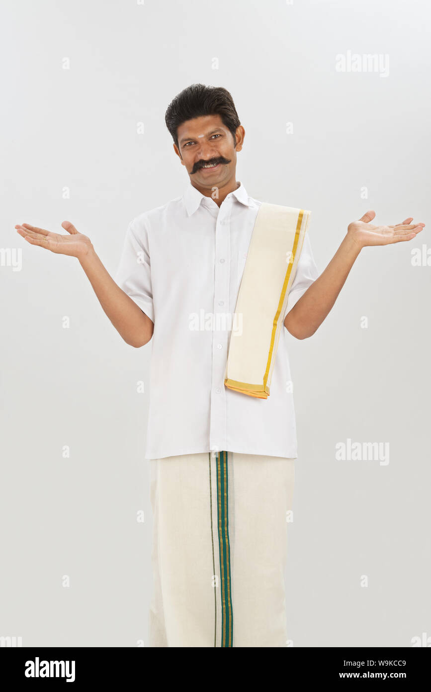 South Indian man smiling with his arm outstretched Stock Photo - Alamy