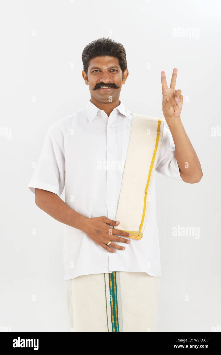 South Indian man showing v sign and smiling Stock Photo - Alamy