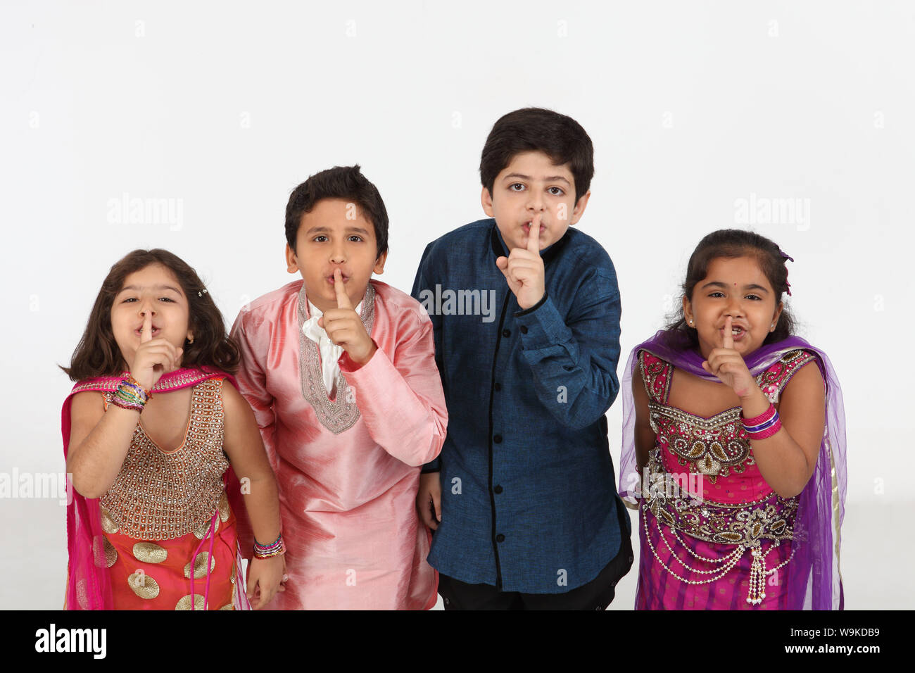 Group of children with finger on lips Stock Photo - Alamy