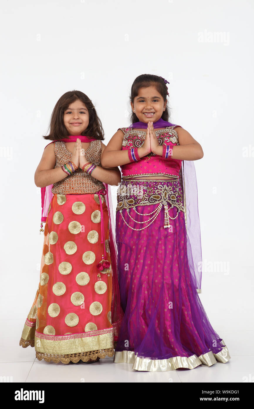 Two girls greeting with hands joined Stock Photo - Alamy