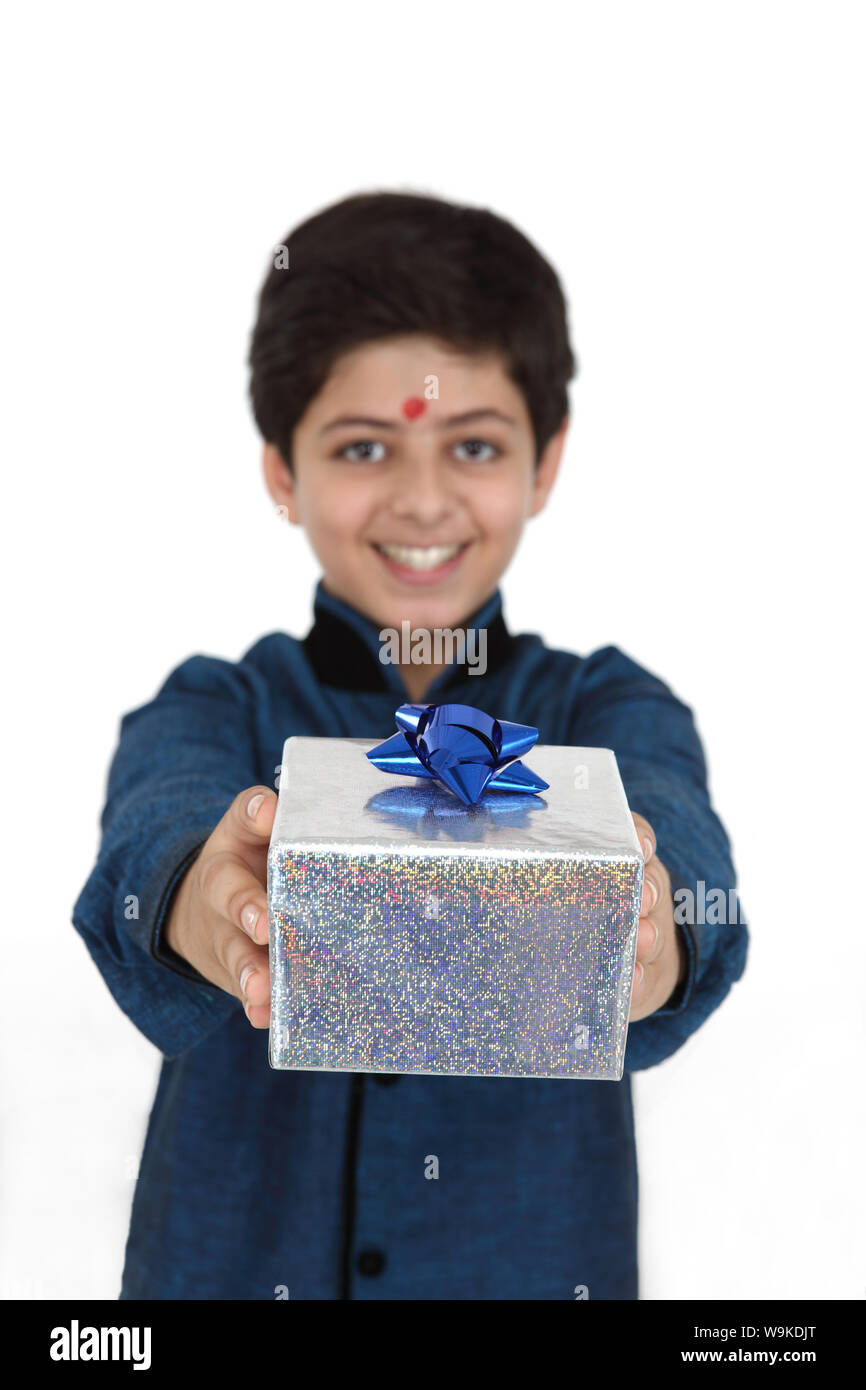 Boy giving a gift box and smiling Stock Photo - Alamy