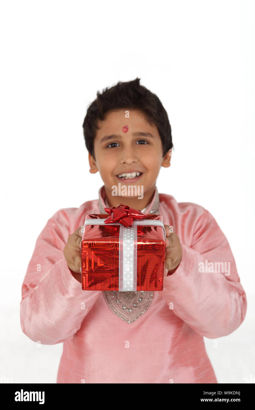Boy holding gift box and smiling Stock Photo - Alamy
