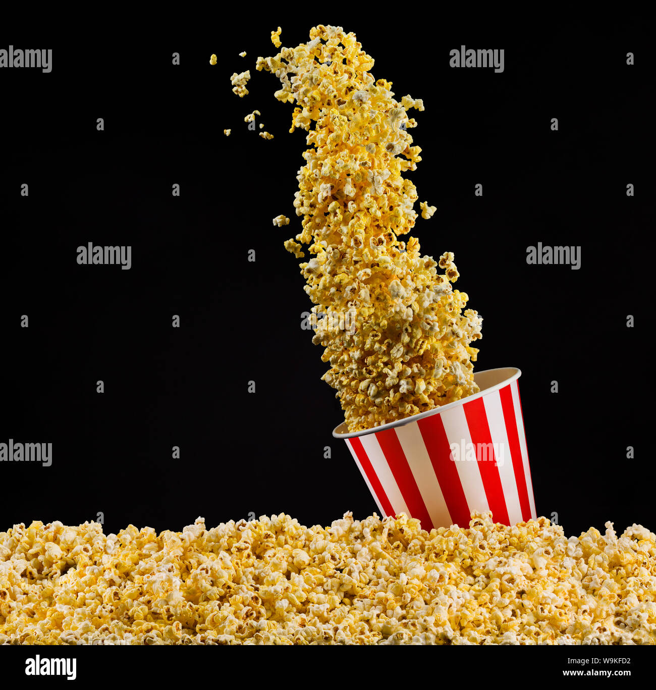 Flying popcorn from striped bucket isolated on black background Stock ...