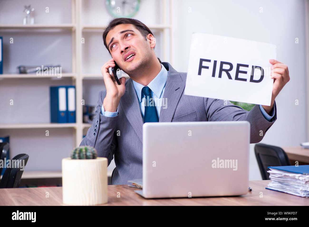 The young male employee being fired from his work Stock Photo - Alamy