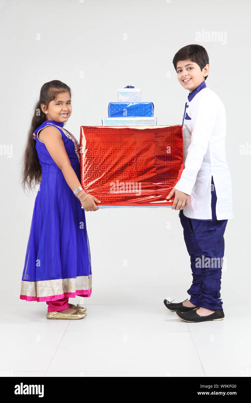 Two children holding gift boxes and smiling Stock Photo - Alamy