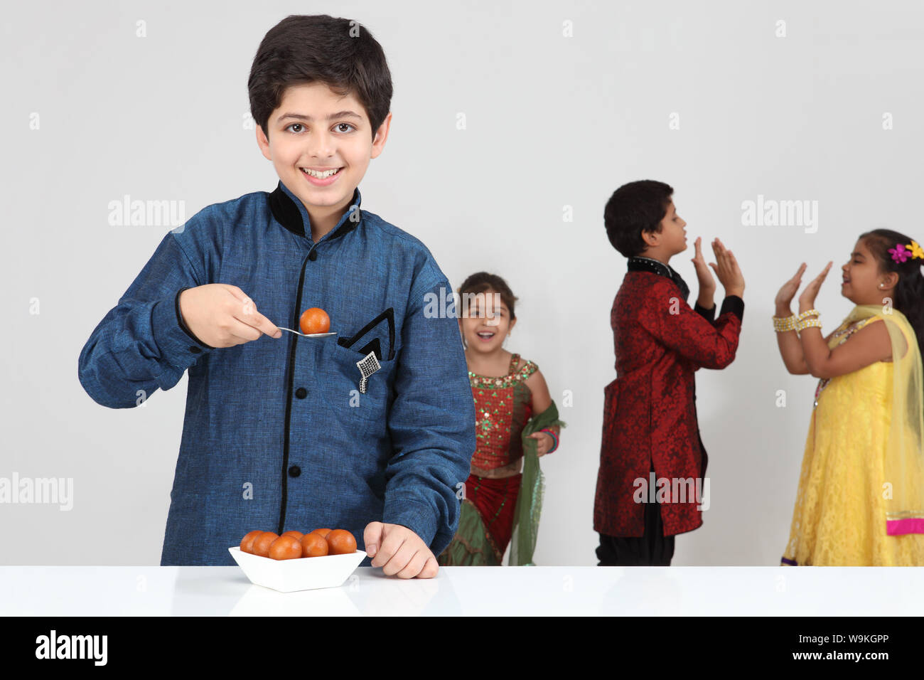 Boy eating gulab jamun with his friends playing in the background Stock ...