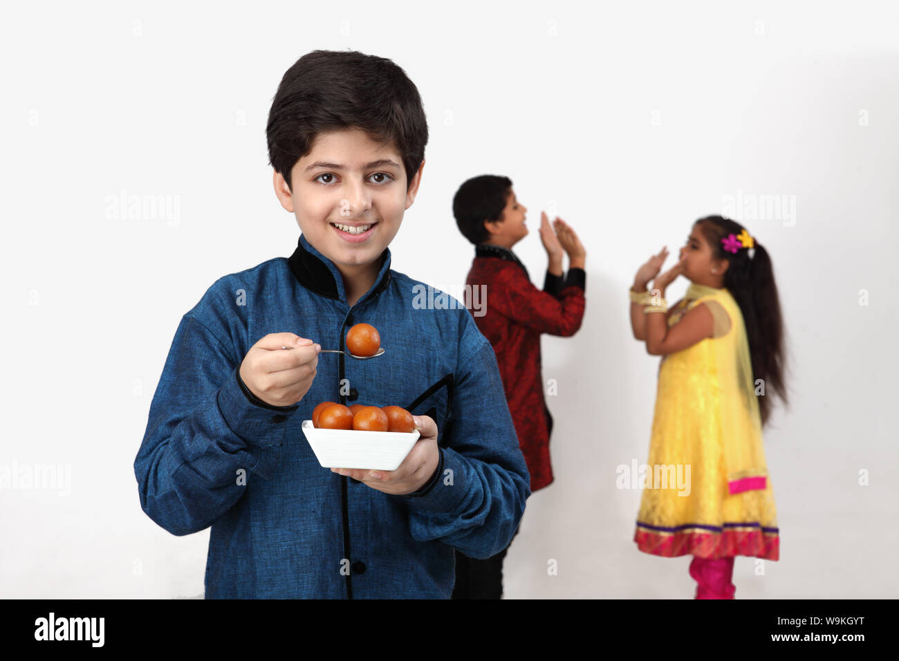 Boy eating gulab jamun with his friends playing in the background Stock ...