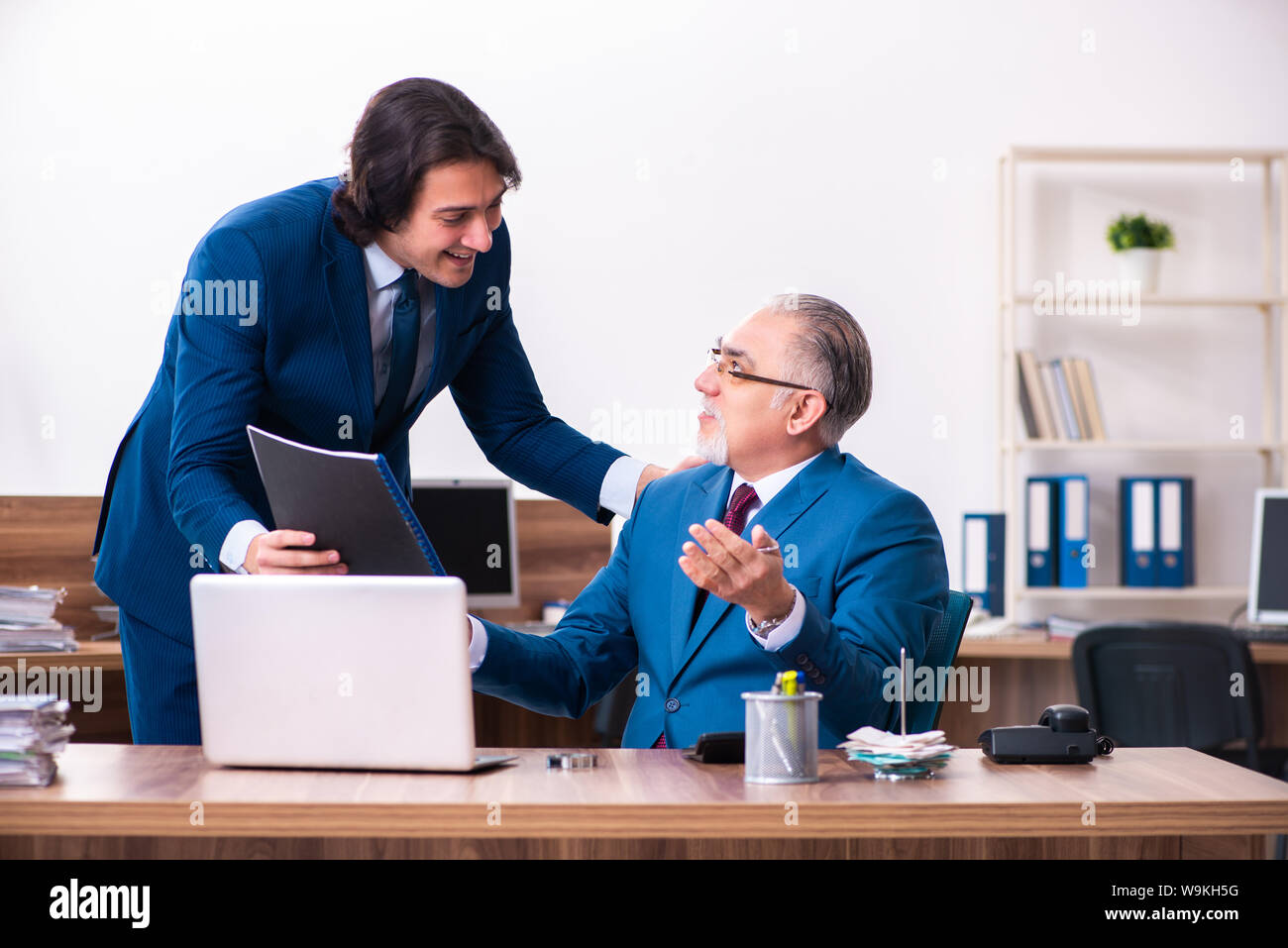 The young and old employees working together in the office Stock Photo ...