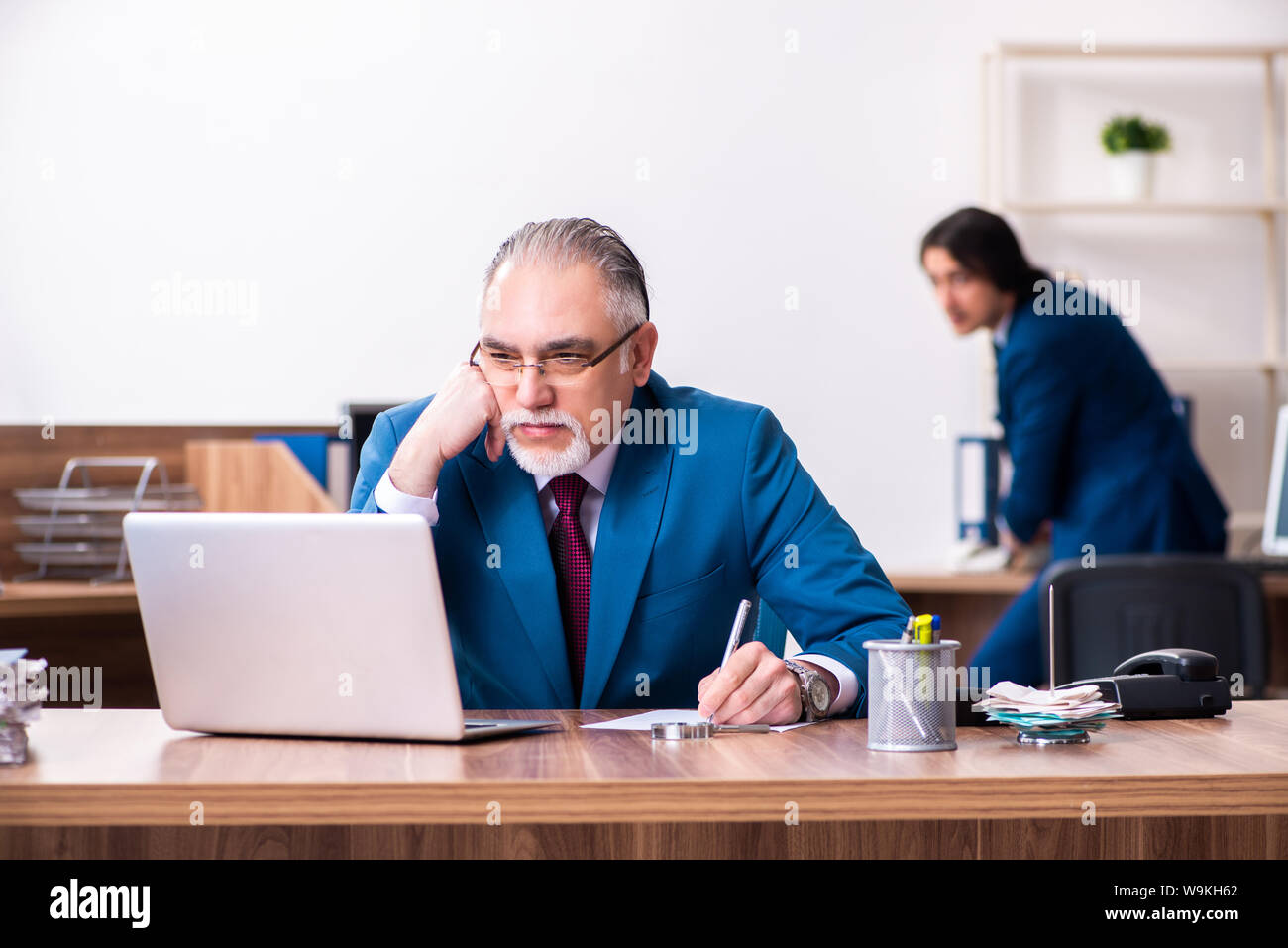 The young and old employees working together in the office Stock Photo ...