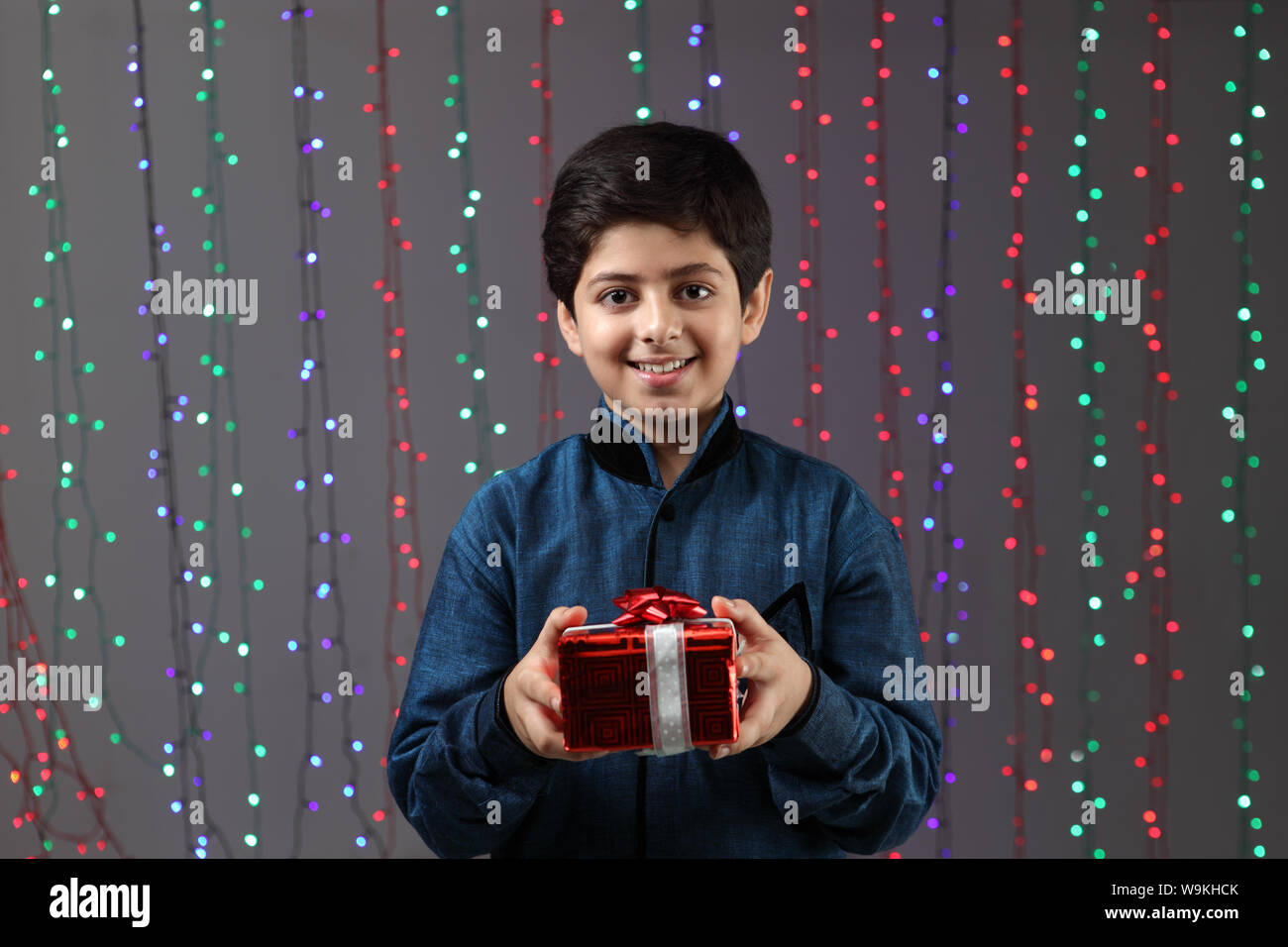 Boy giving a gift box and smiling Stock Photo - Alamy