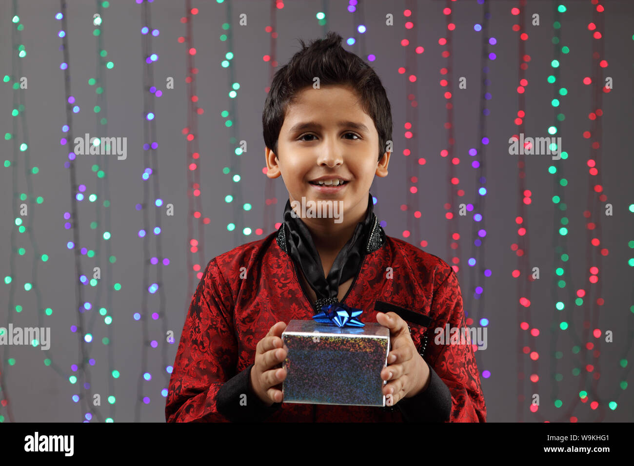 Boy holding gift box and smiling Stock Photo - Alamy