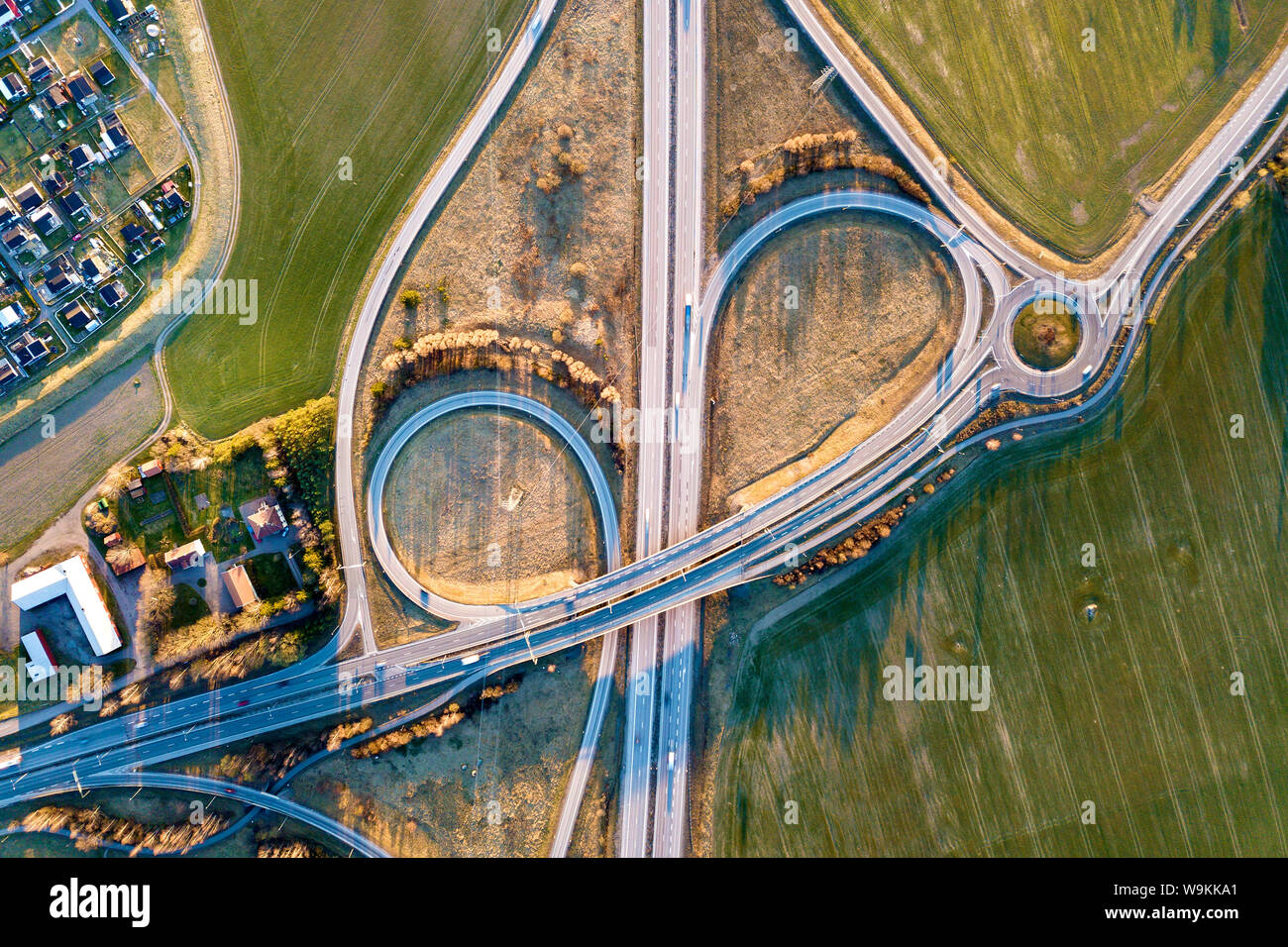 Aerial top view of modern highway road intersection, house roofs on ...