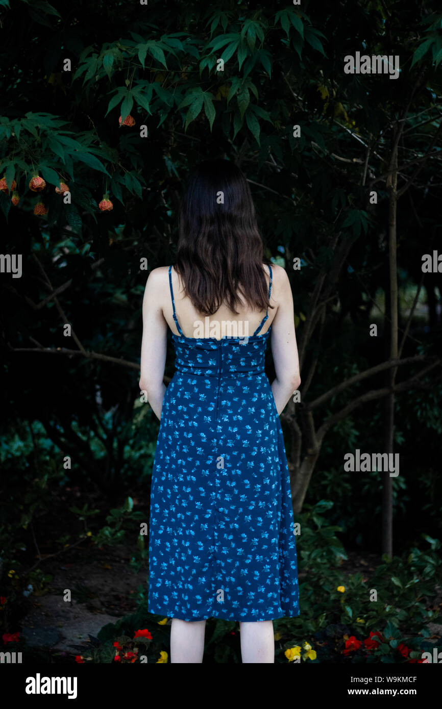 Model facing backwards against a tree Stock Photo - Alamy
