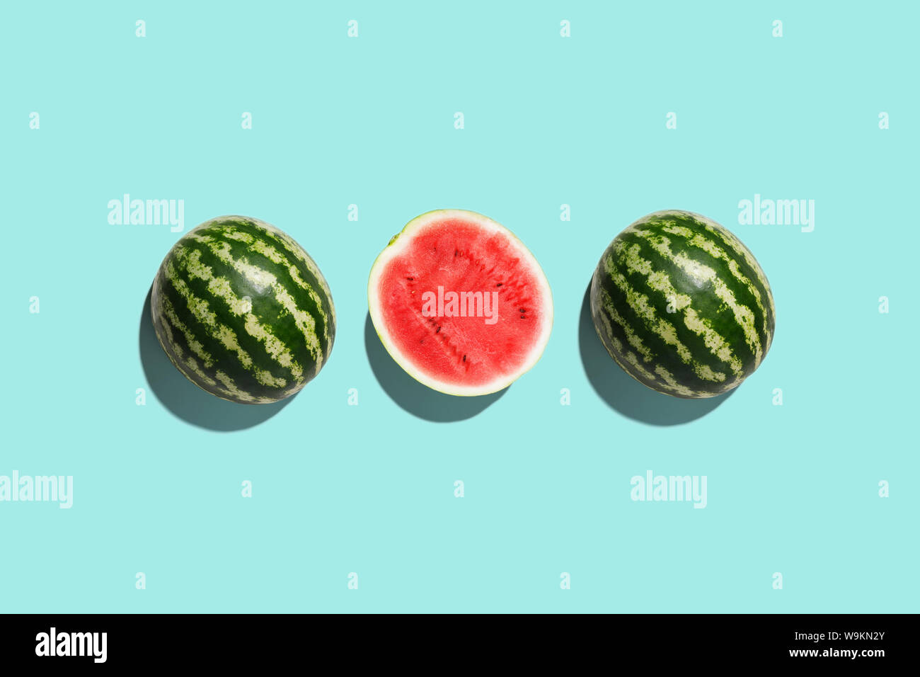 Three halves of watermelon in a row isolated on blue background Stock ...