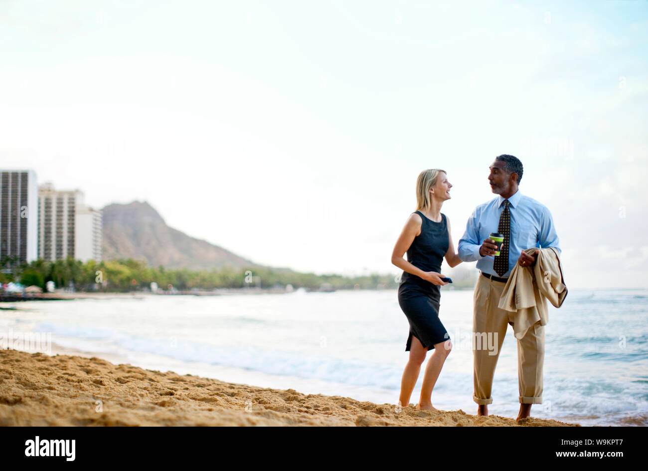 Two business partners enjoy walking on the beach together Stock Photo ...