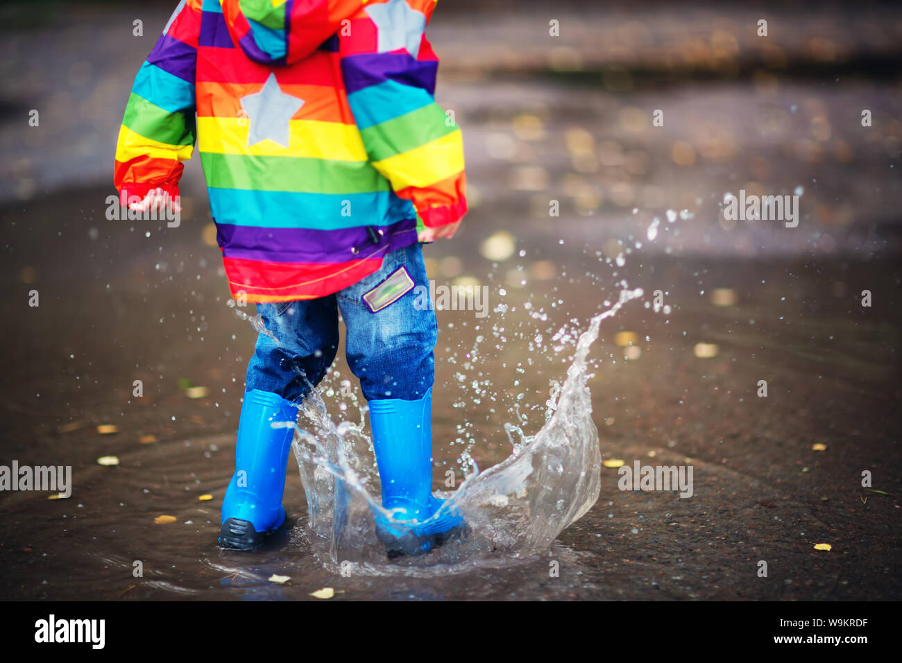Child walking in wellies in puddle on rainy weather Stock Photo - Alamy