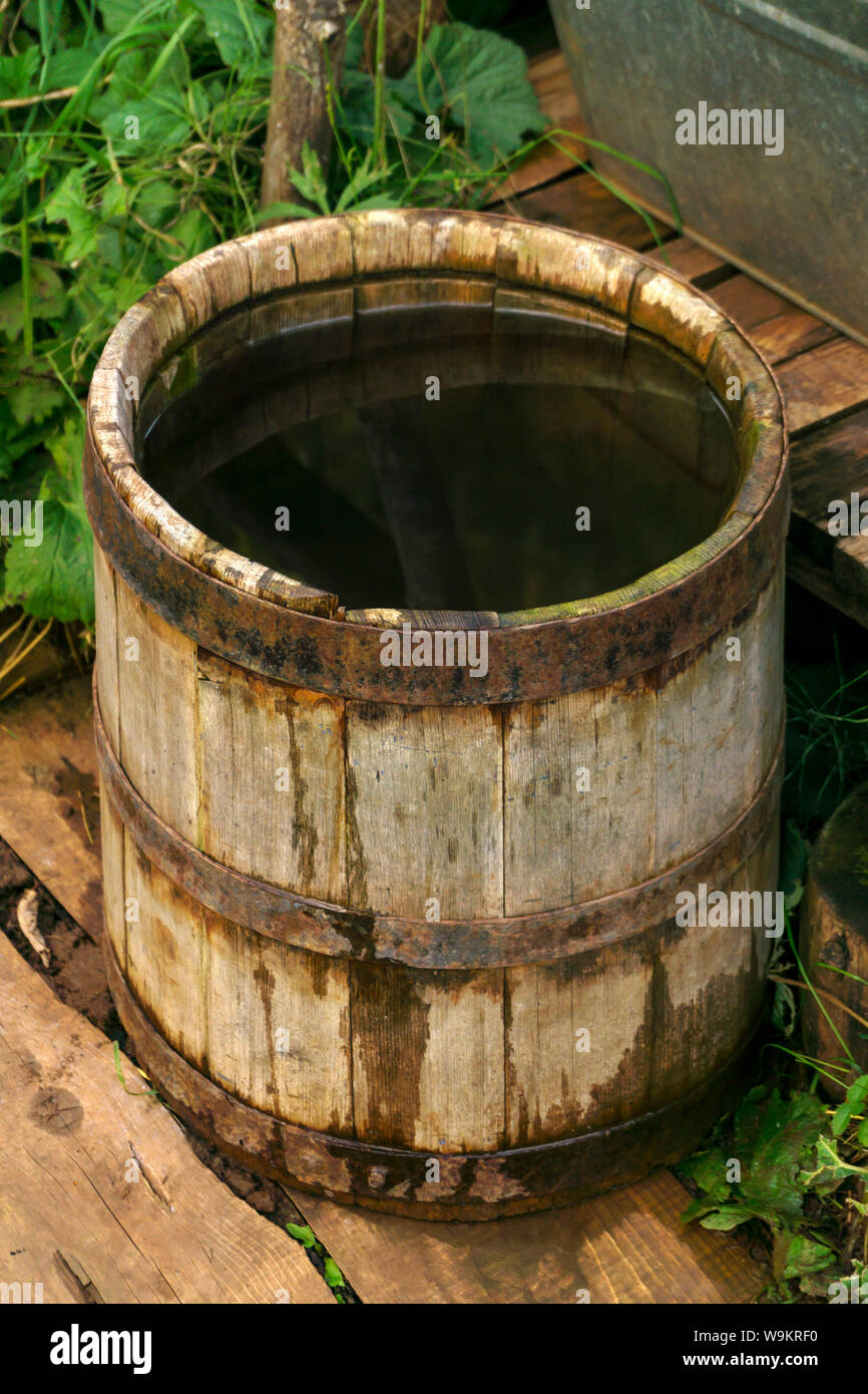 ancient wooden bucket with water stands in the backyard outdoor Stock ...