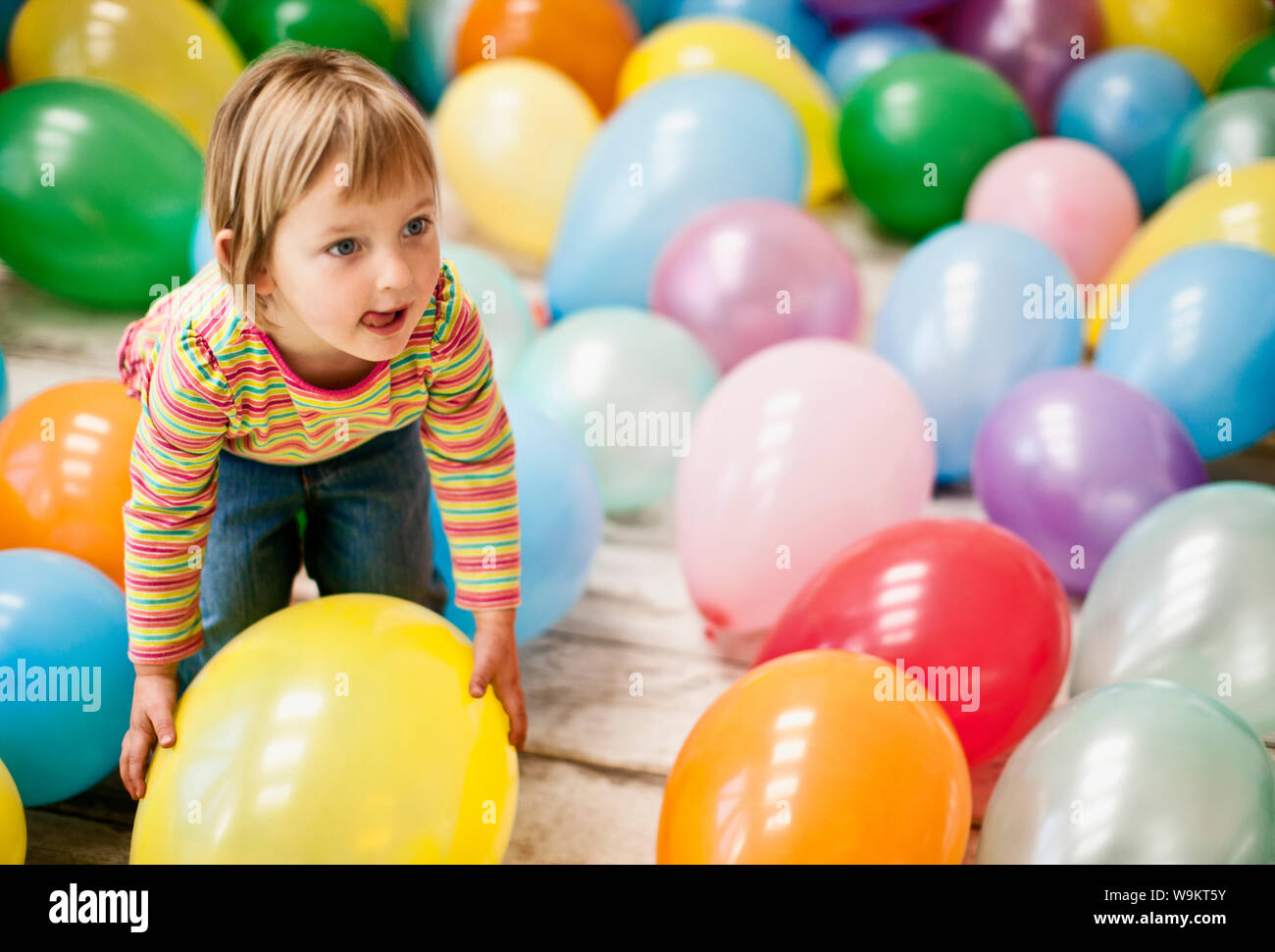 Little girl having fun in a room full of balloons Stock Photo - Alamy