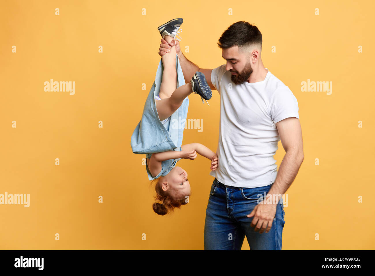 angry frustrated guy holding his naughty sister's leg and scolding her ...