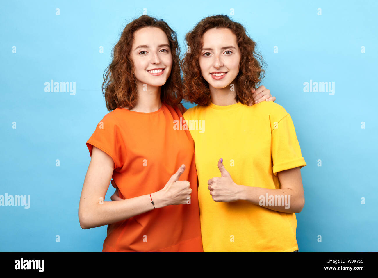 Two pretty brunette twins smiling hi-res stock photography and images ...
