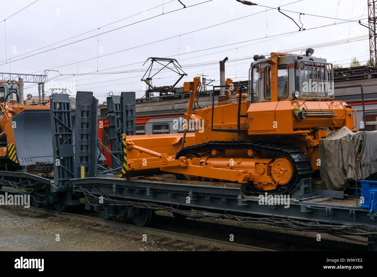 heavy orange bulldozer stands on the flatcar of the train for accident ...